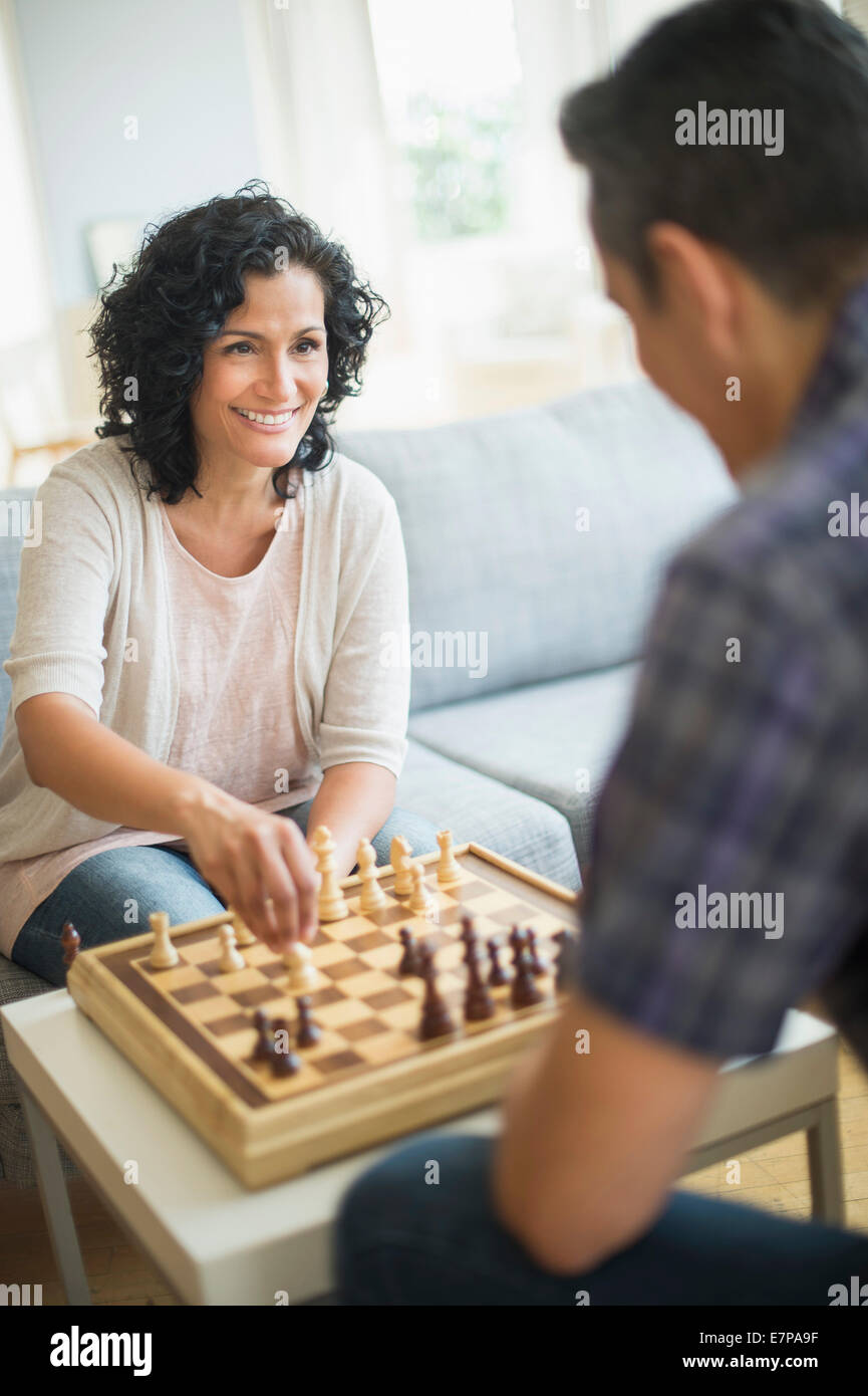 Couple playing chess in living room Stock Photo - Alamy