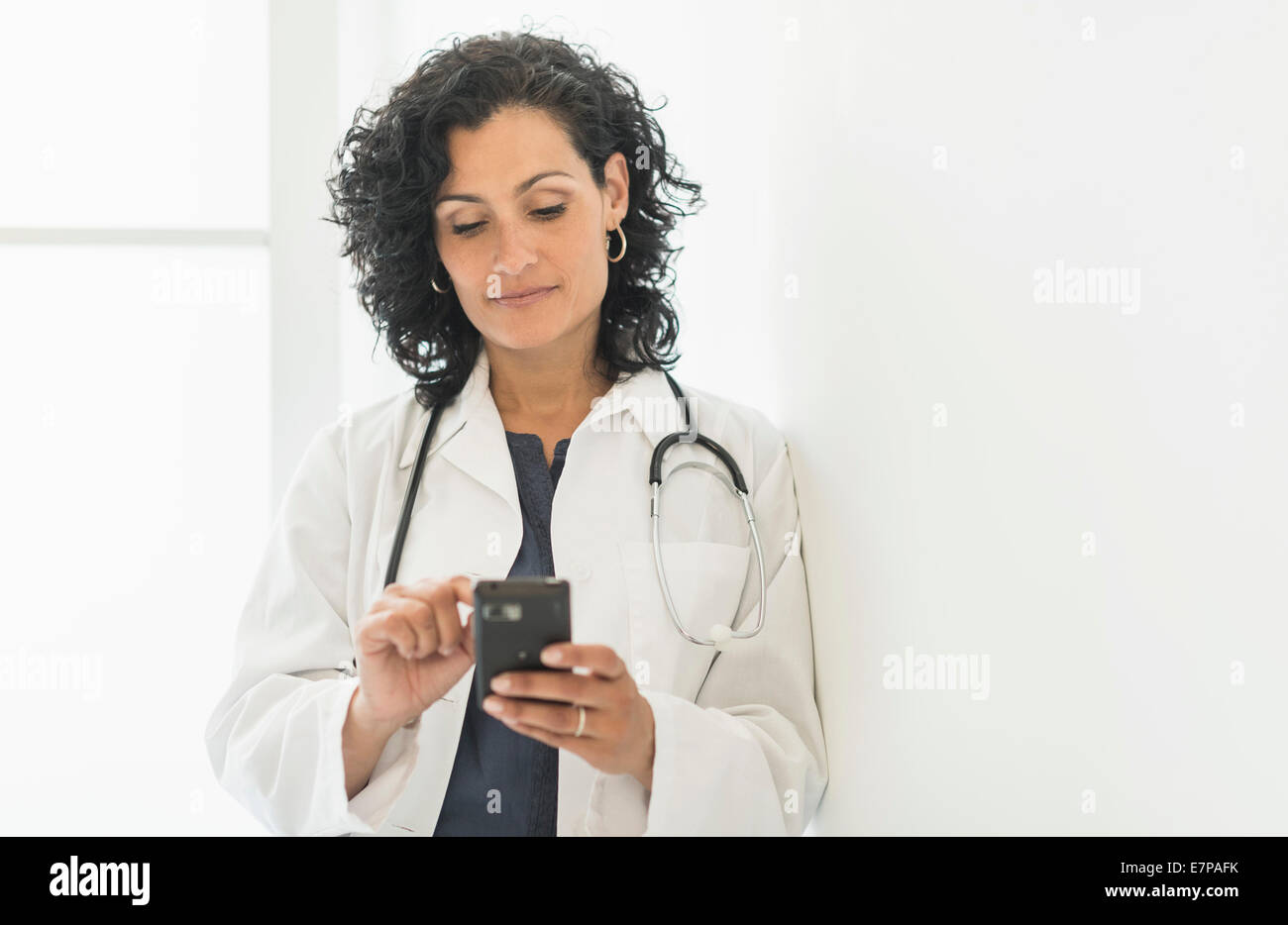 Female doctor using cell phone Stock Photo - Alamy