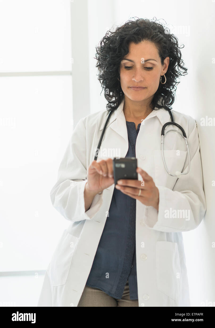 Female doctor using cell phone Stock Photo - Alamy