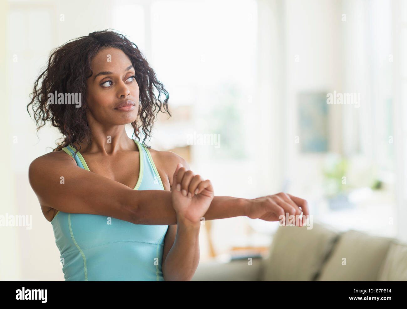 Woman stretching in living room Stock Photo - Alamy