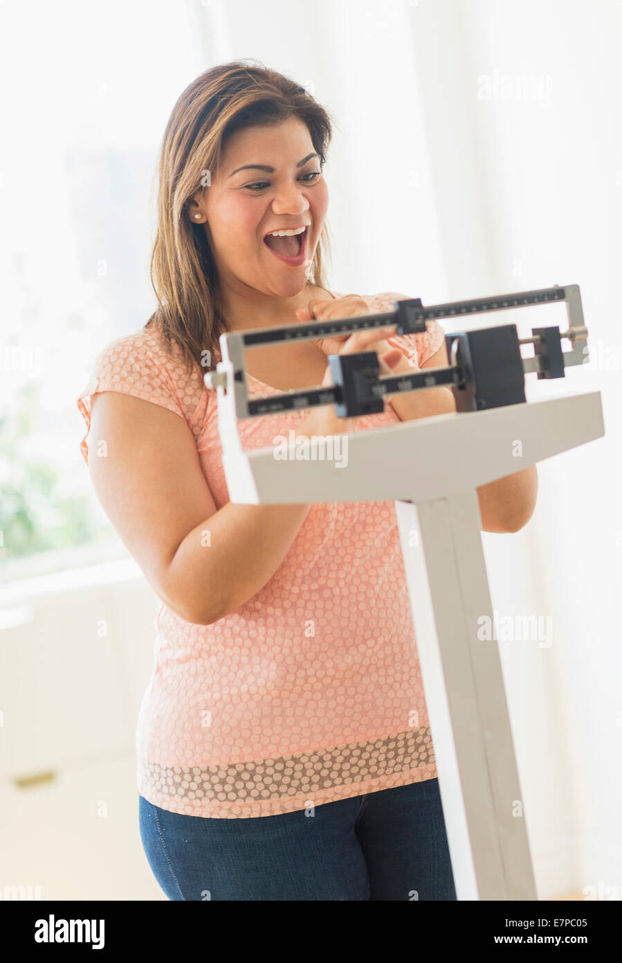 Happy woman standing on scale Stock Photo - Alamy