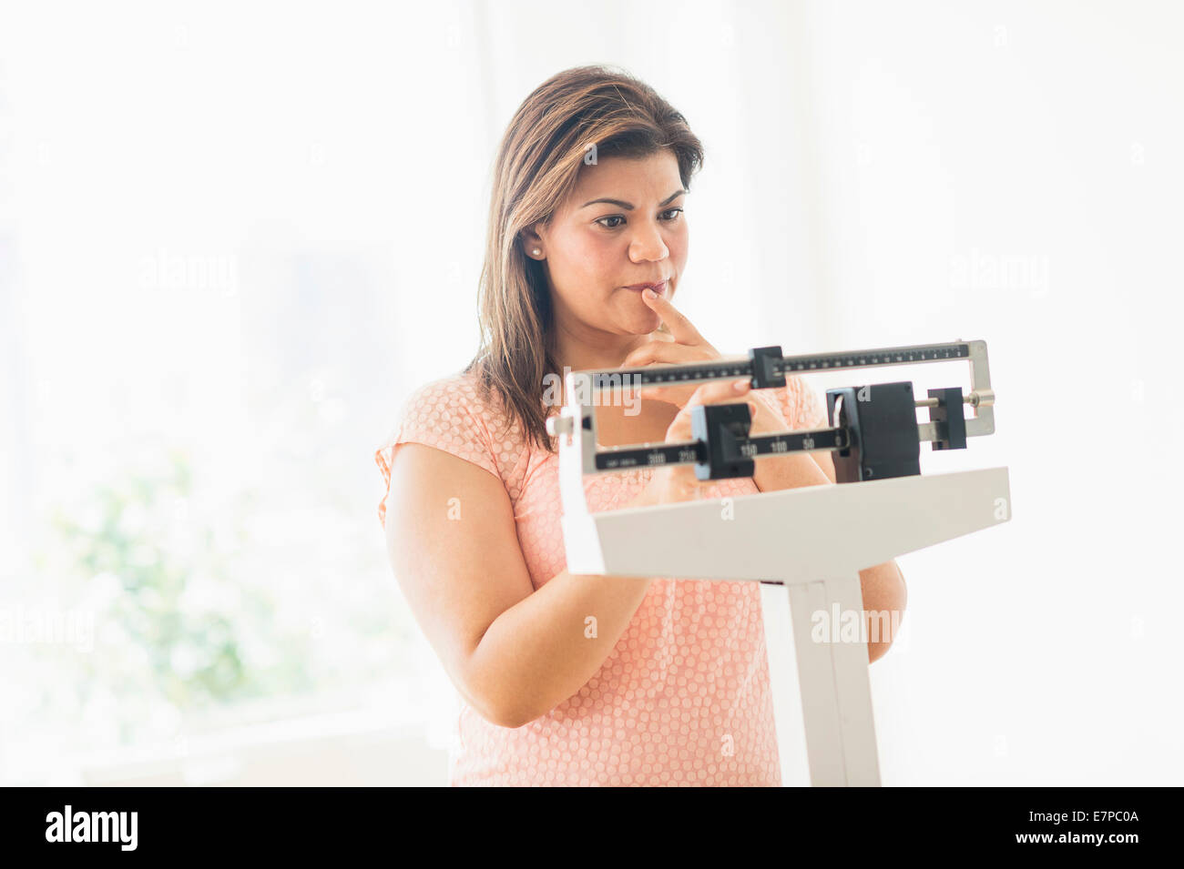 Woman standing on scale Stock Photo - Alamy
