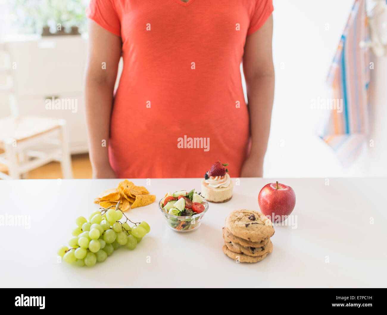 Woman standing by counter in kitchen Stock Photo - Alamy