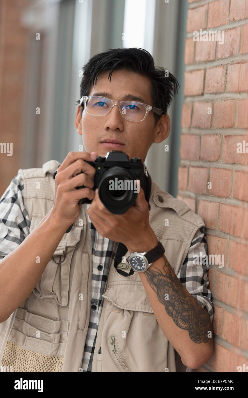 Portrait of man holding camera Stock Photo - Alamy
