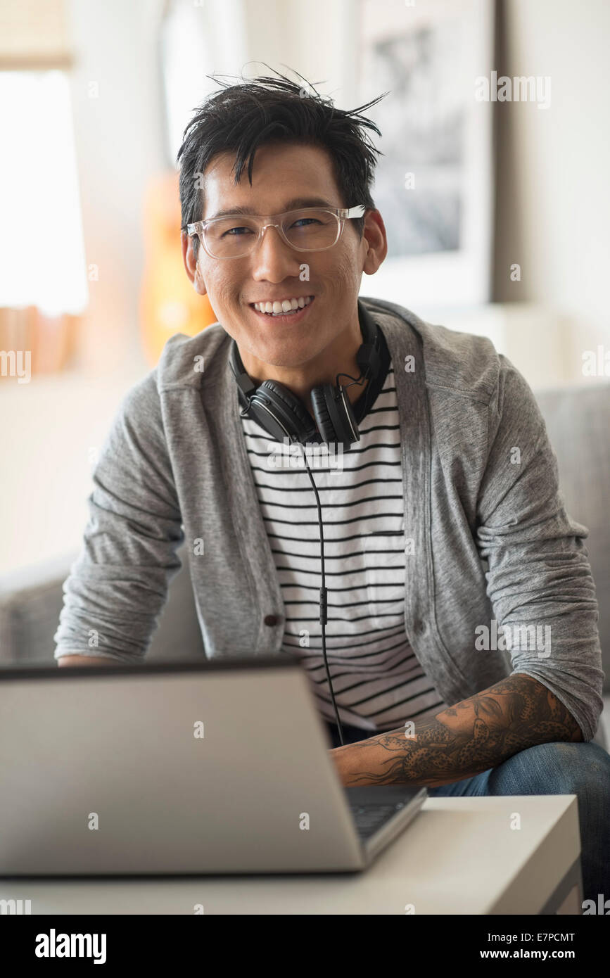 Portrait of man with headphones in front of laptop Stock Photo - Alamy