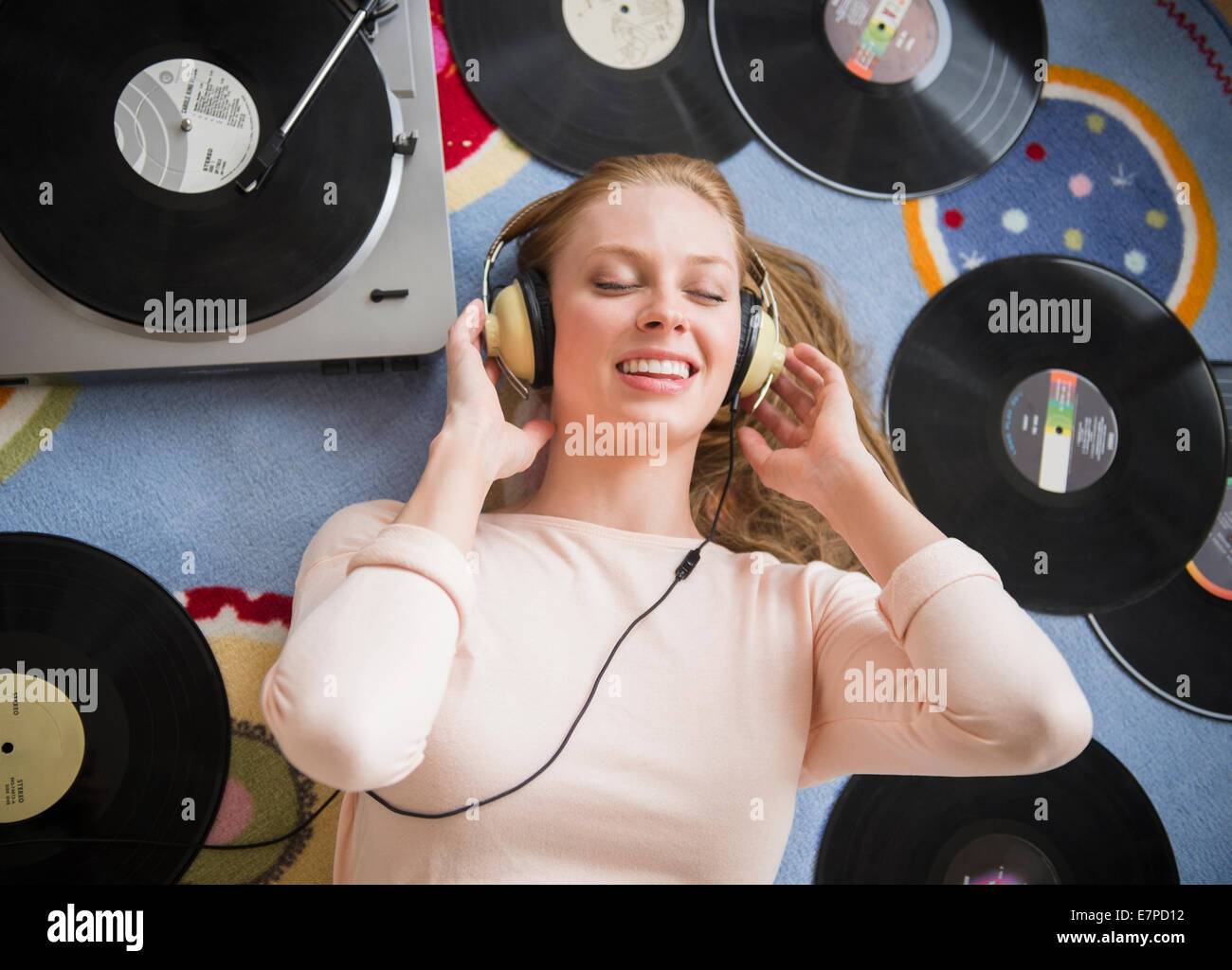 Young woman listening to music on vinyl record Stock Photo - Alamy