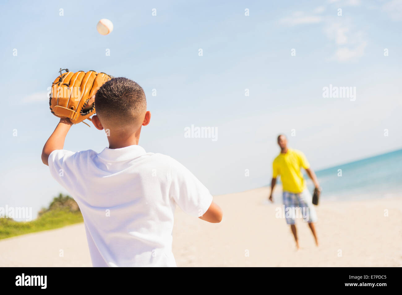 USA, Florida, Jupiter, Father and son (10-11) playing baseball on beach ...