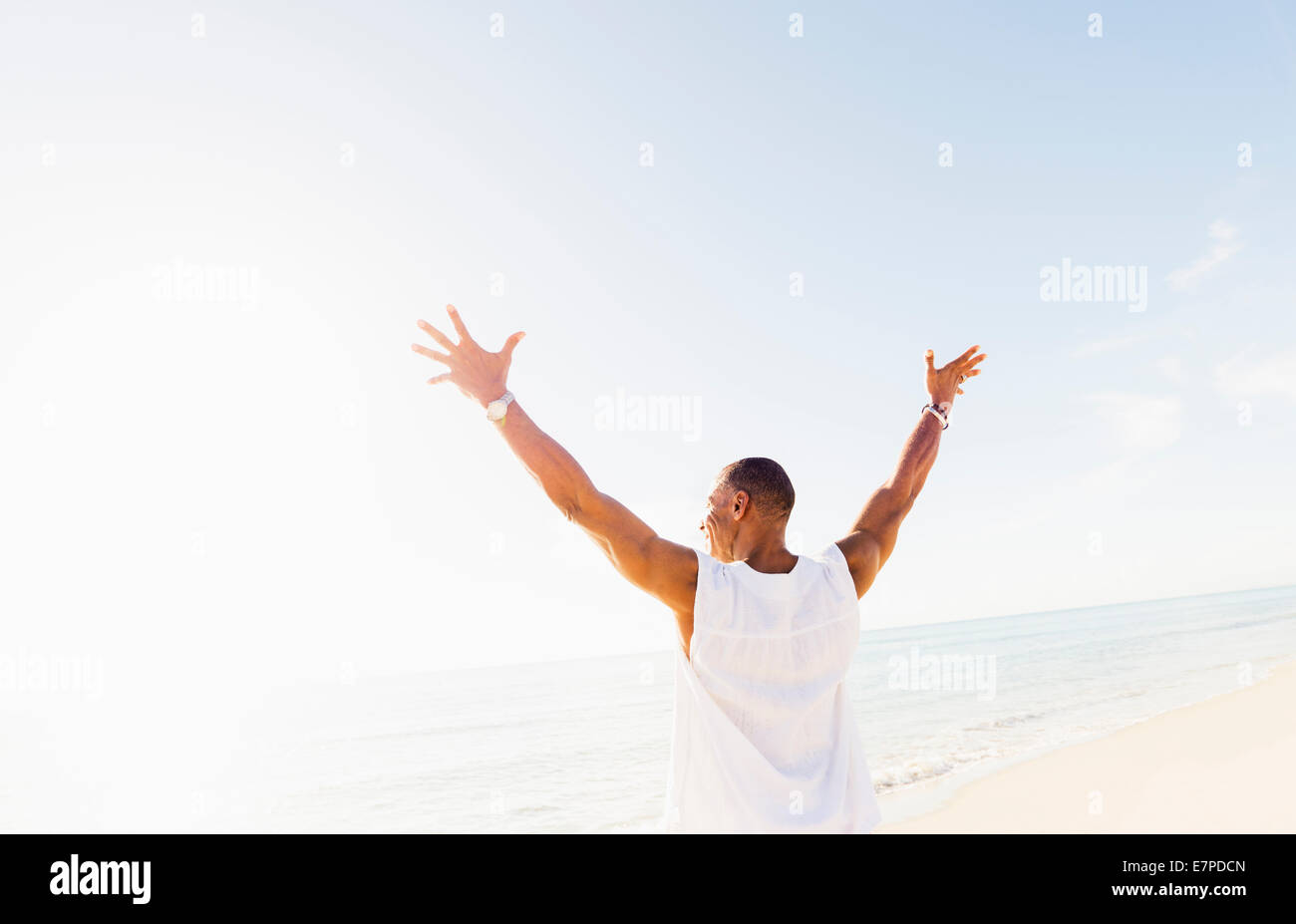 Man raising arms on beach Stock Photo - Alamy