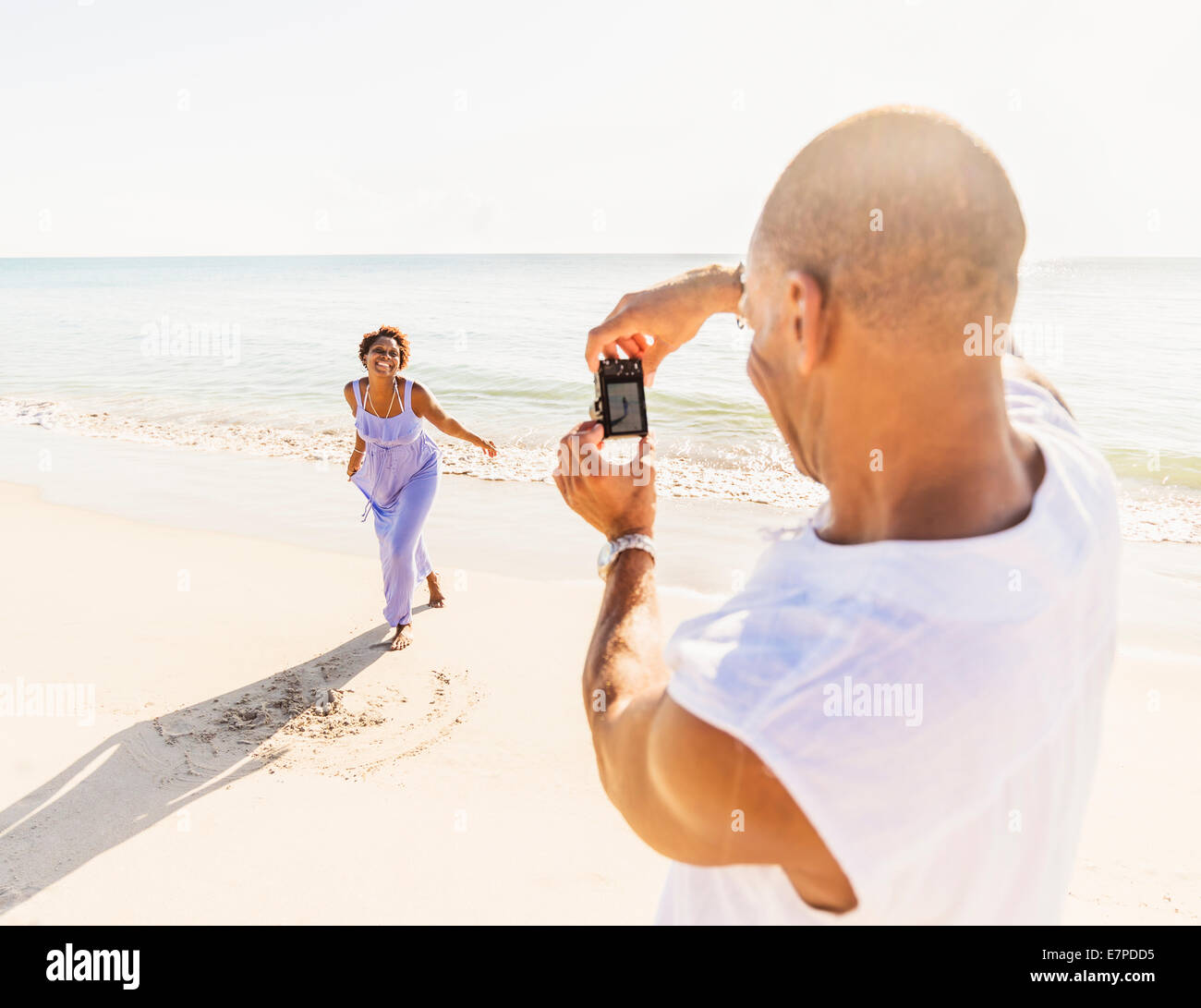 Man photographing woman on beach Stock Photo - Alamy
