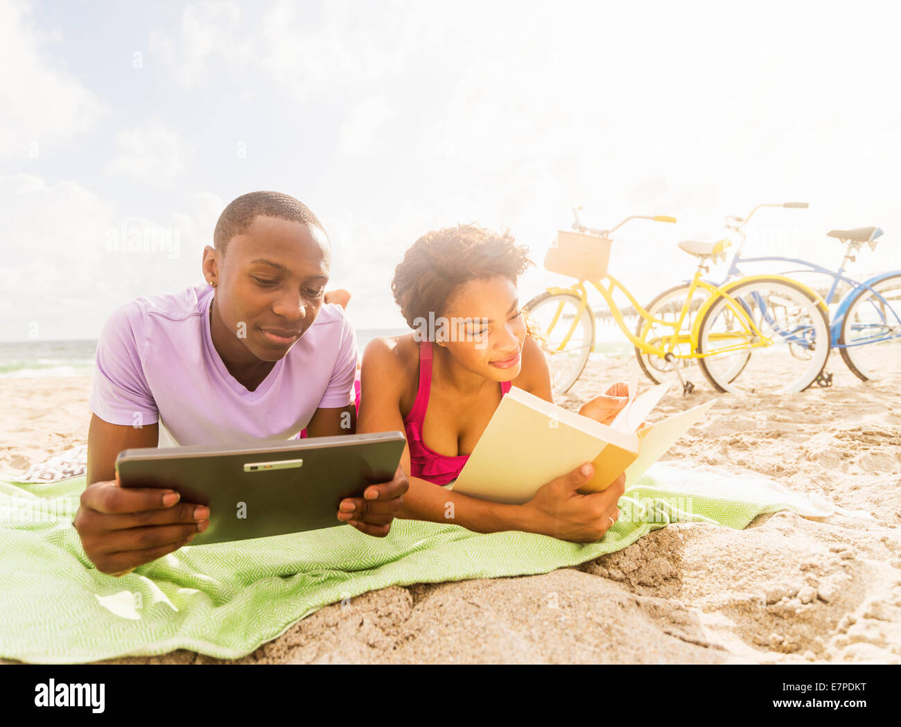Young men reading book on beach hi-res stock photography and images - Alamy