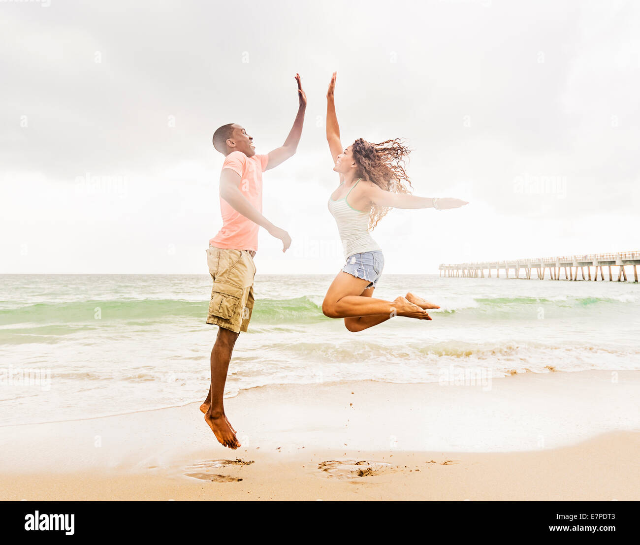 Couple on beach, woman jumping over man hi-res stock photography and ...