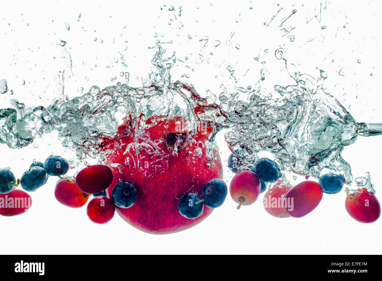 Studio shot of fruits falling into water Stock Photo - Alamy