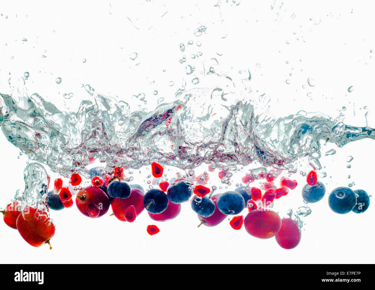 Studio shot of fruits falling into water Stock Photo - Alamy
