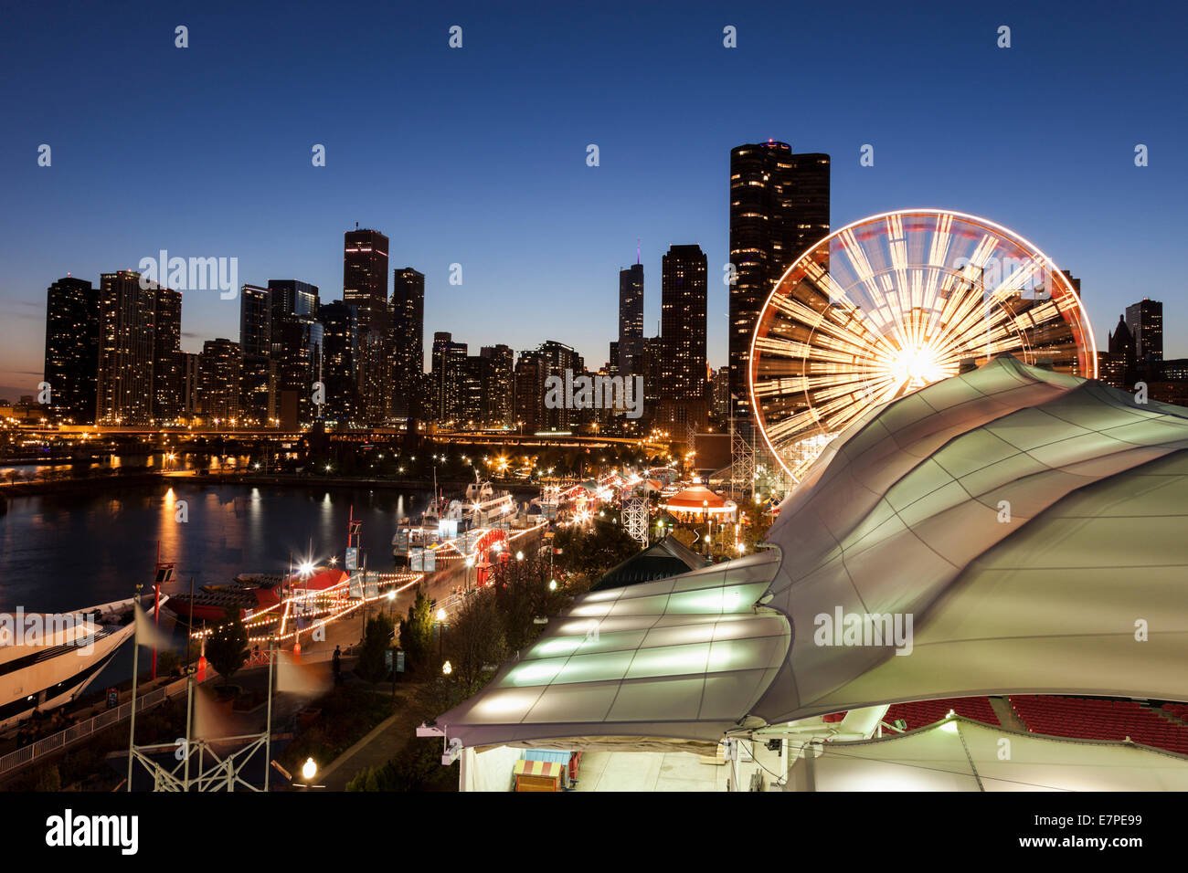USA, Illinois, Chicago, Illuminated ferris wheel with skyscrapers in ...