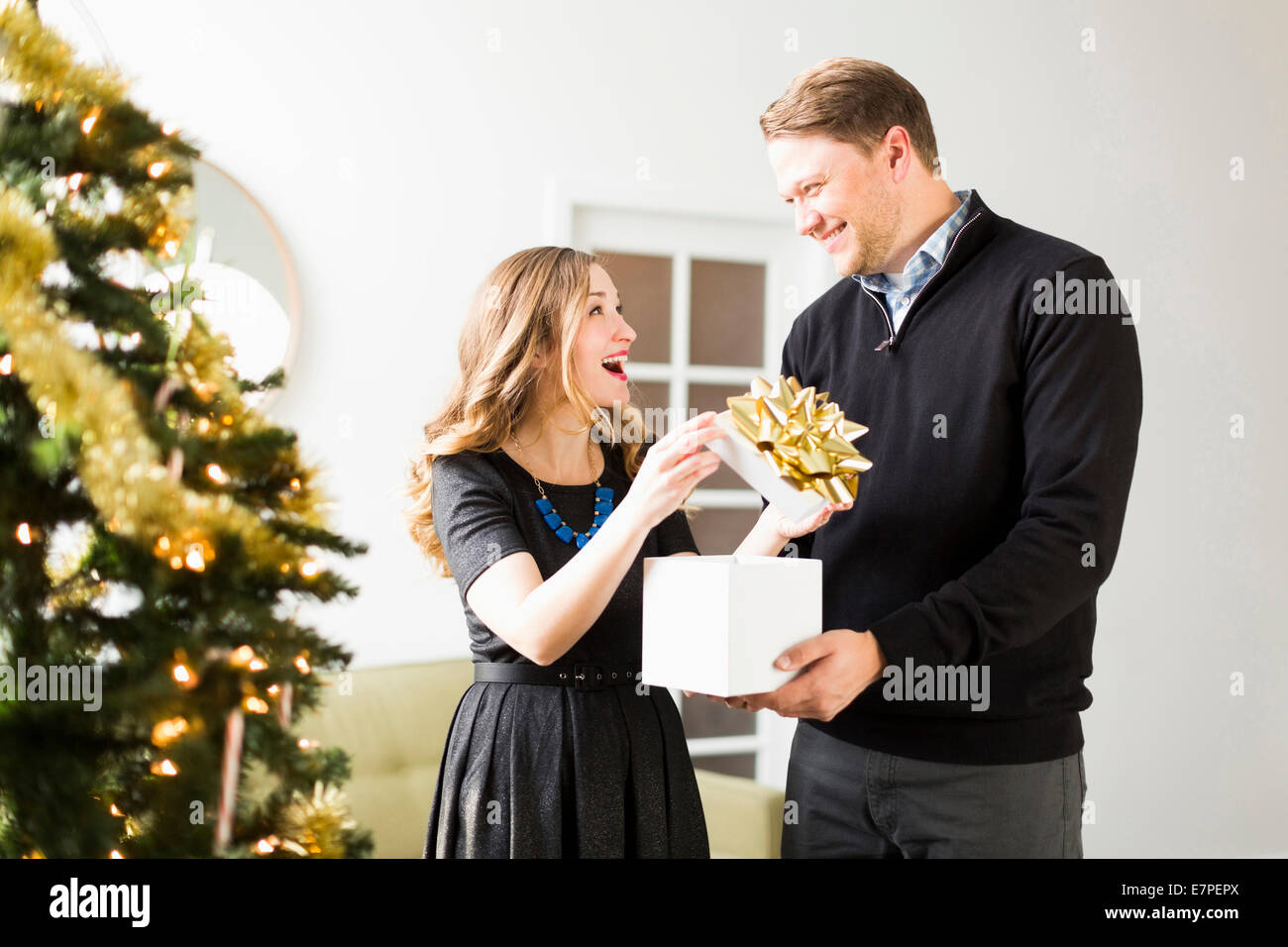 Woman opening present from man Stock Photo - Alamy