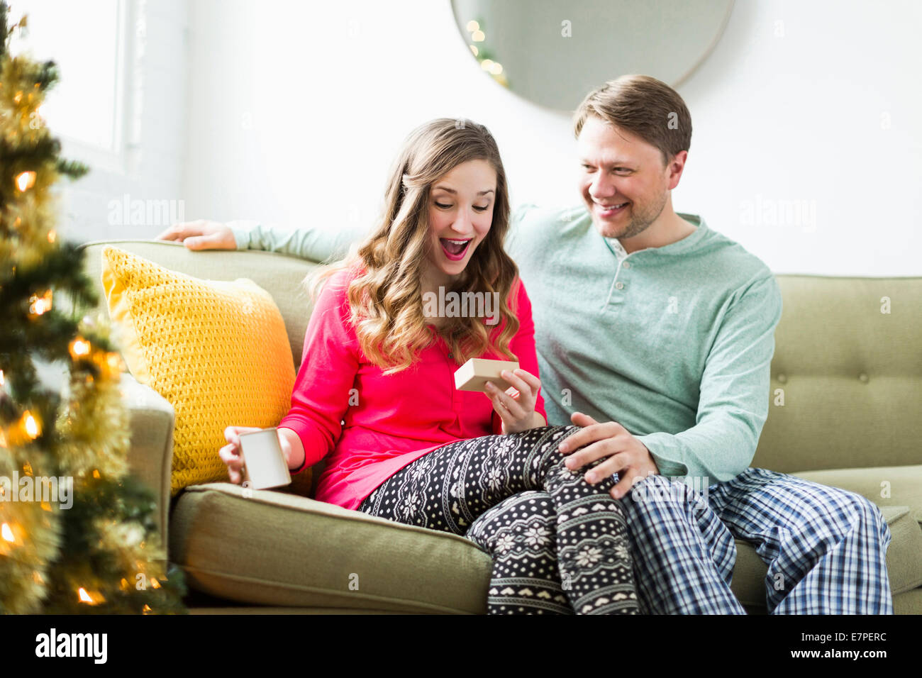 Young woman surprised with Christmas gift Stock Photo - Alamy