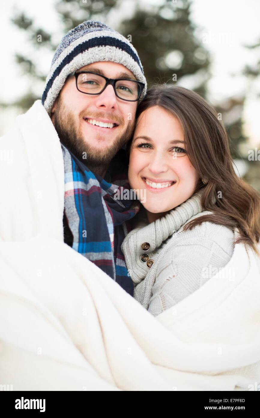 Portrait of couple wrapped in blanket smiling outdoors Stock Photo - Alamy