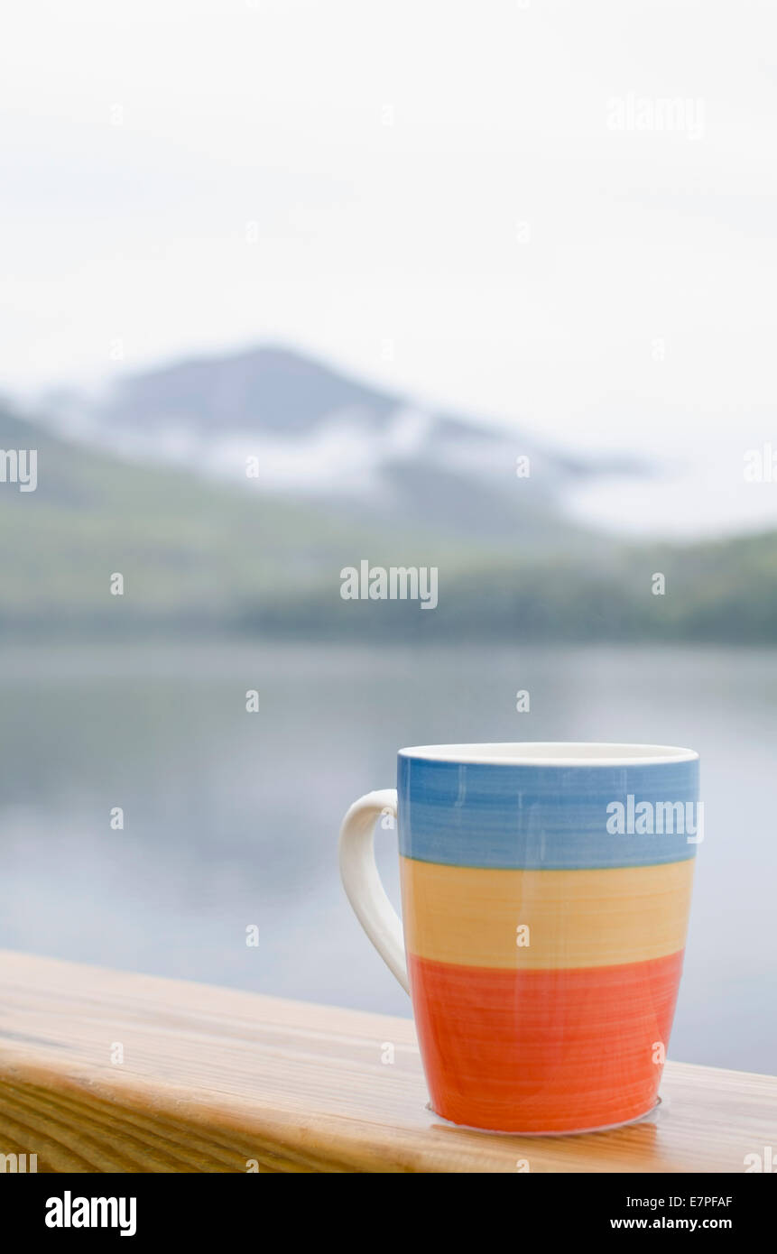 USA, New York State, Lake Placid, Close-up of mug on balustrade, lake ...