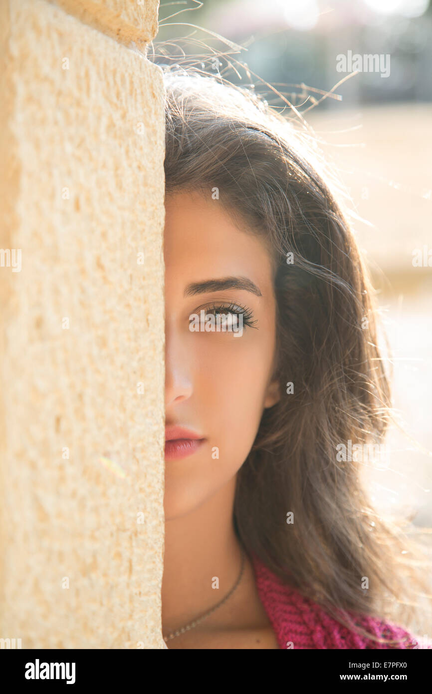 Young woman hiding behind a wall Stock Photo - Alamy