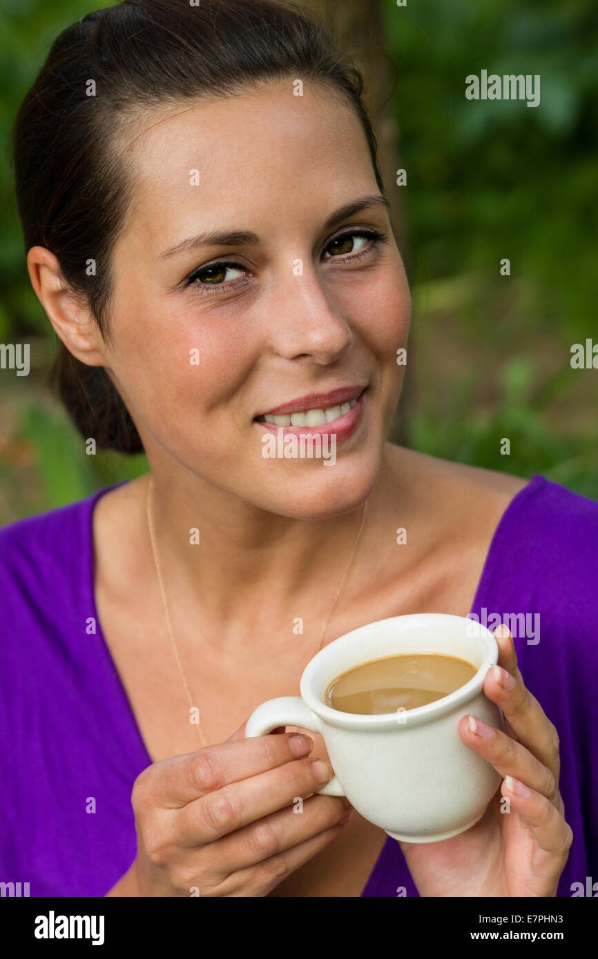 Beautiful young woman drinking coffee outdoors Stock Photo - Alamy