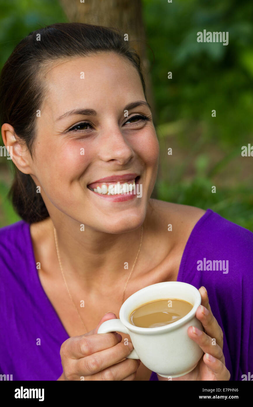 Beautiful young woman drinking coffee outdoors Stock Photo - Alamy