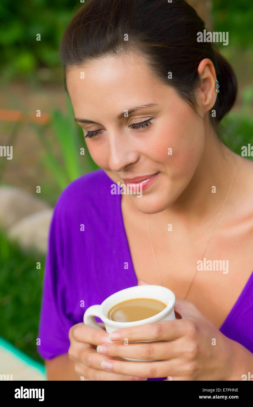 Beautiful young woman drinking hot coffee outdoors Stock Photo - Alamy