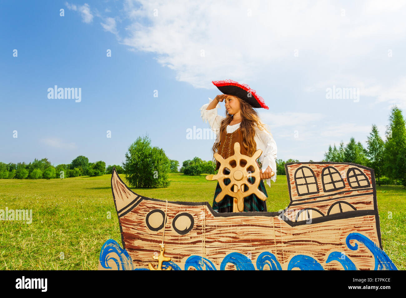 Girl as pirate holds helm and bends her arm Stock Photo - Alamy