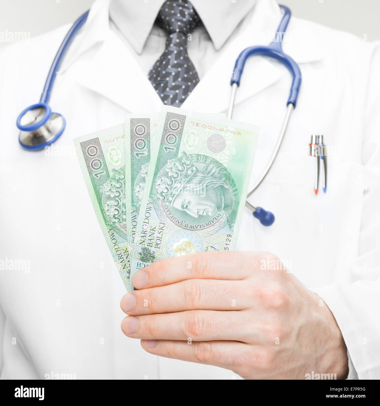 Medical doctor holding money in his hand - 1 to 1 ratio Stock Photo - Alamy