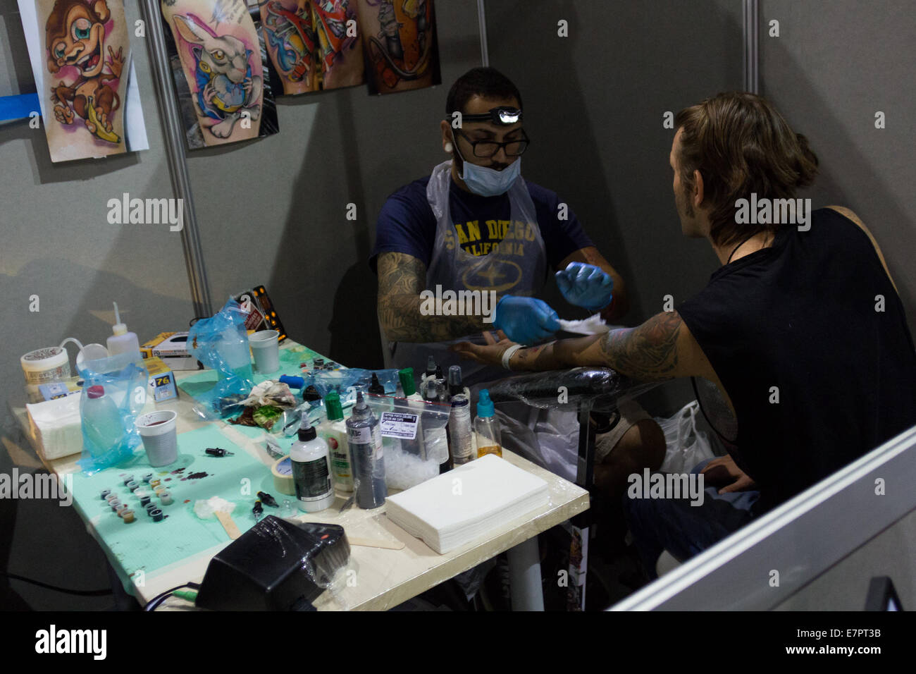 The tattoo artist works a tattoo art for his customer during the ...