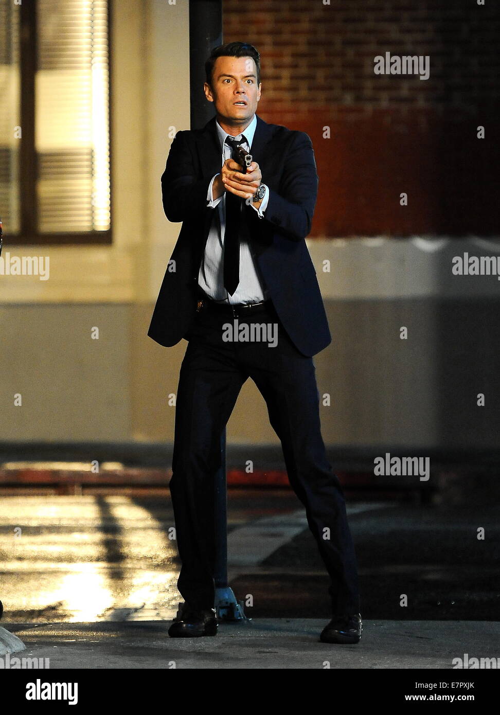 Josh Duhamel raises his gun at suspects on the set of his new show ...
