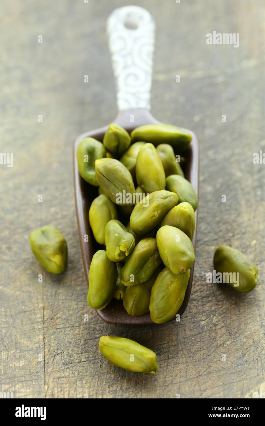 peeled green pistachio nuts on a wooden background Stock Photo - Alamy