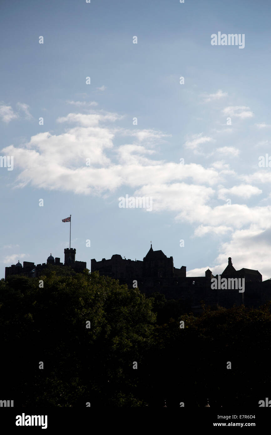 A silhouette of Edinburgh castle with the Union Jack flag flying on top ...