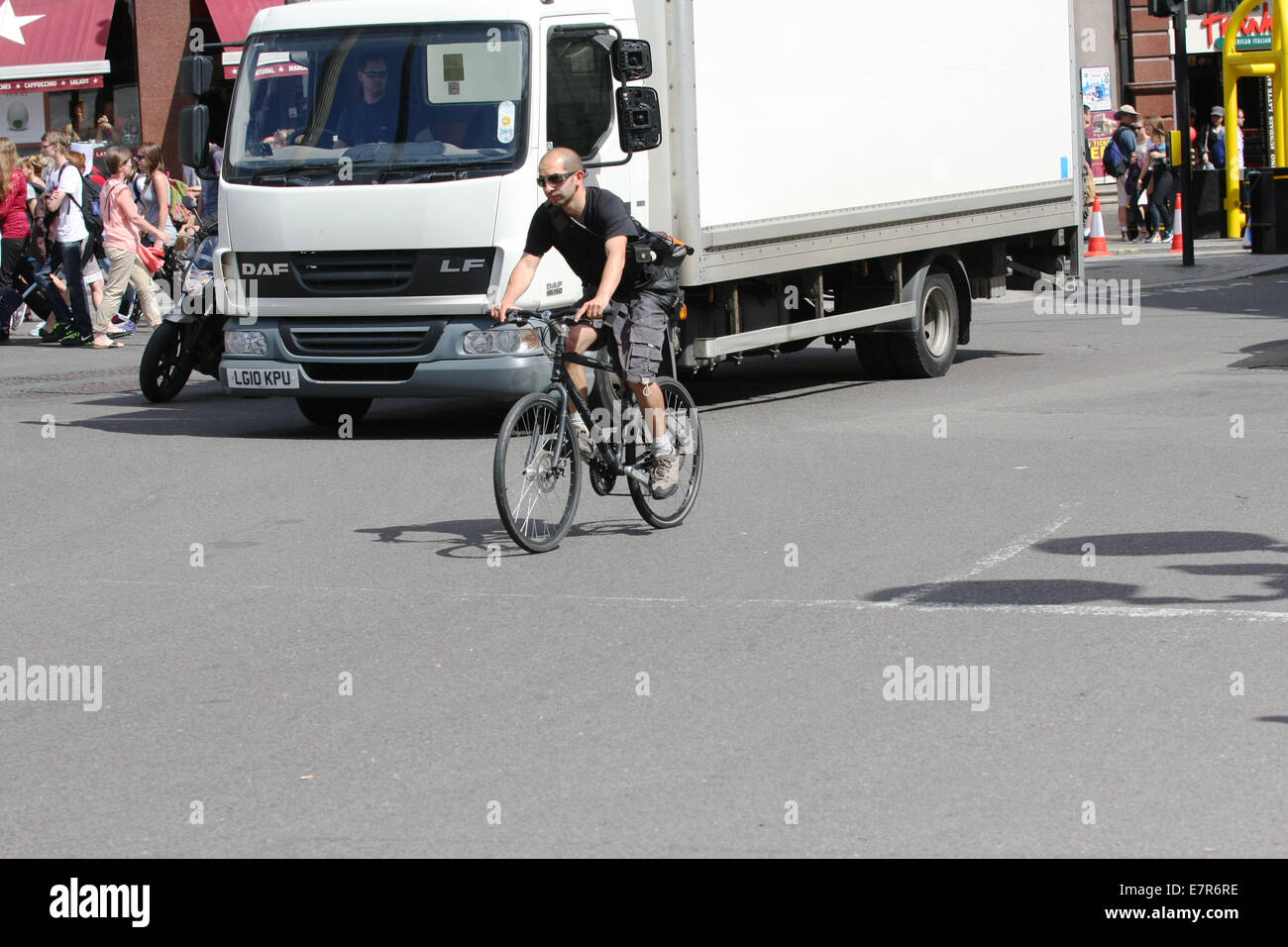 A cyclist and truck traveling along a road in London Stock Photo - Alamy