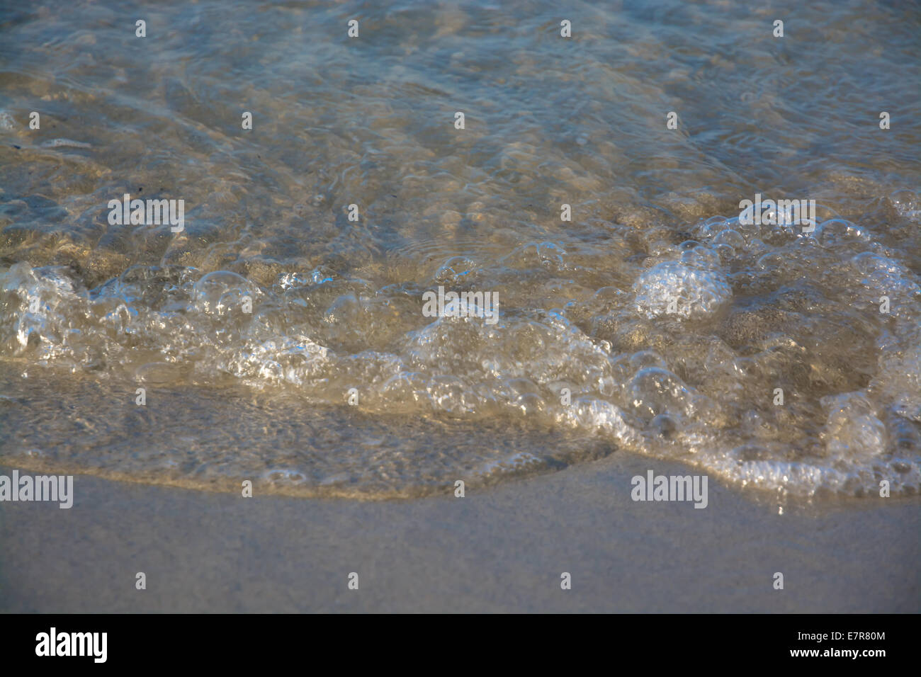 Beach closeup of bubbly wave on sandy beach. Mallorca, Balearic islands ...