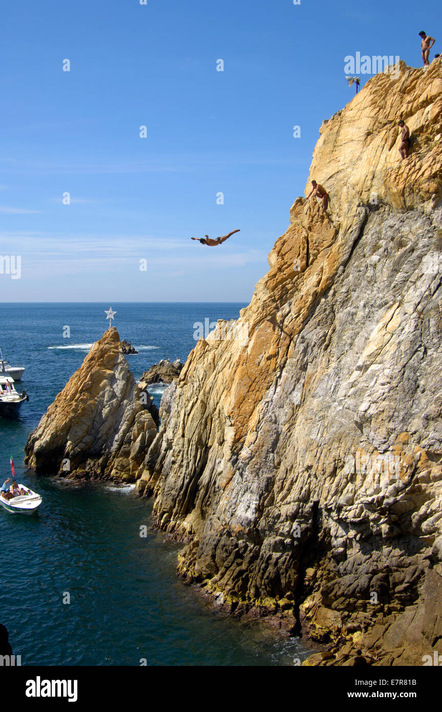 A cliff diver plunges headlong into the ravine at Quebrada in Acapulco ...