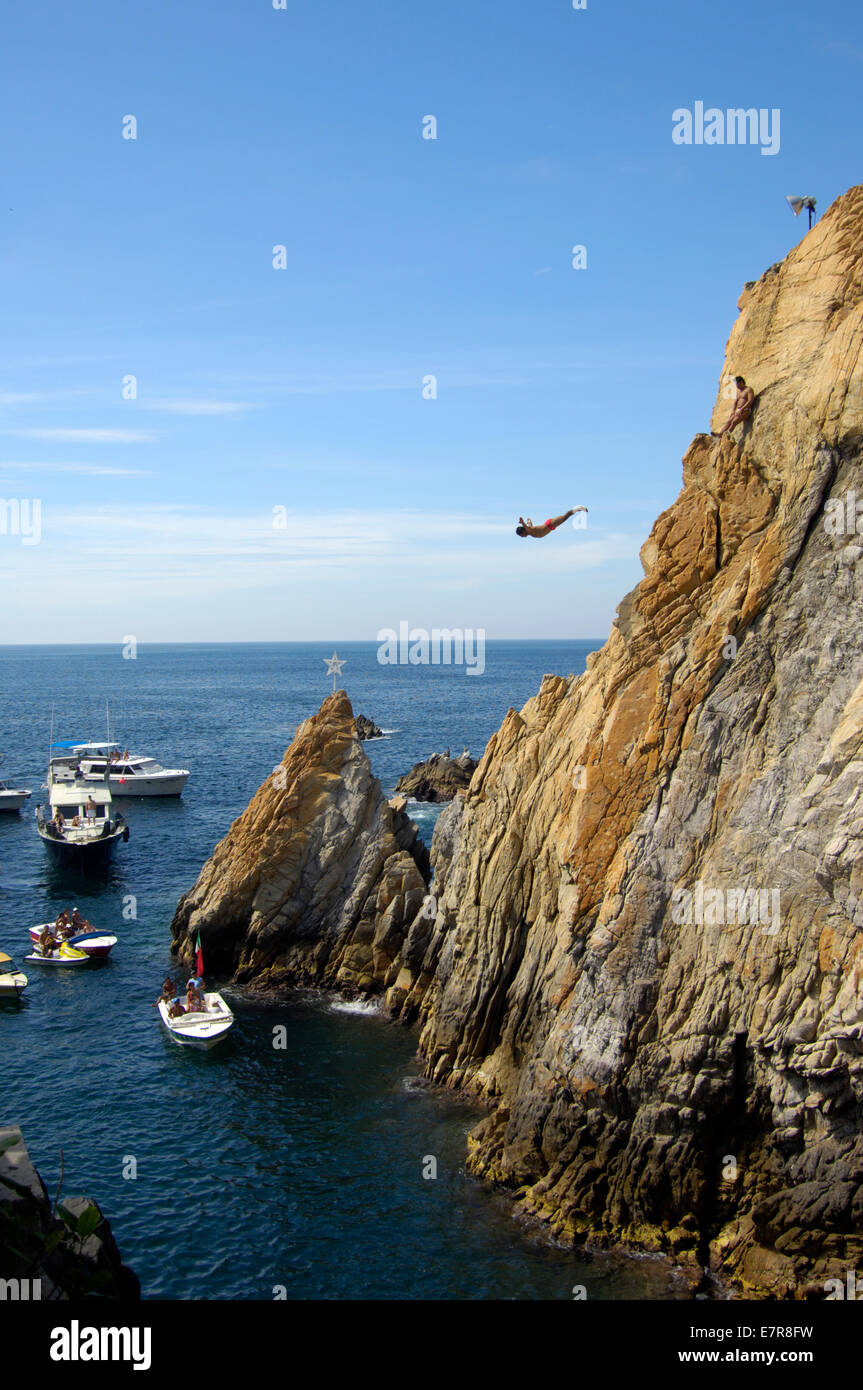 A cliff diver plunges headlong into the ravine at Quebrada in Acapulco ...