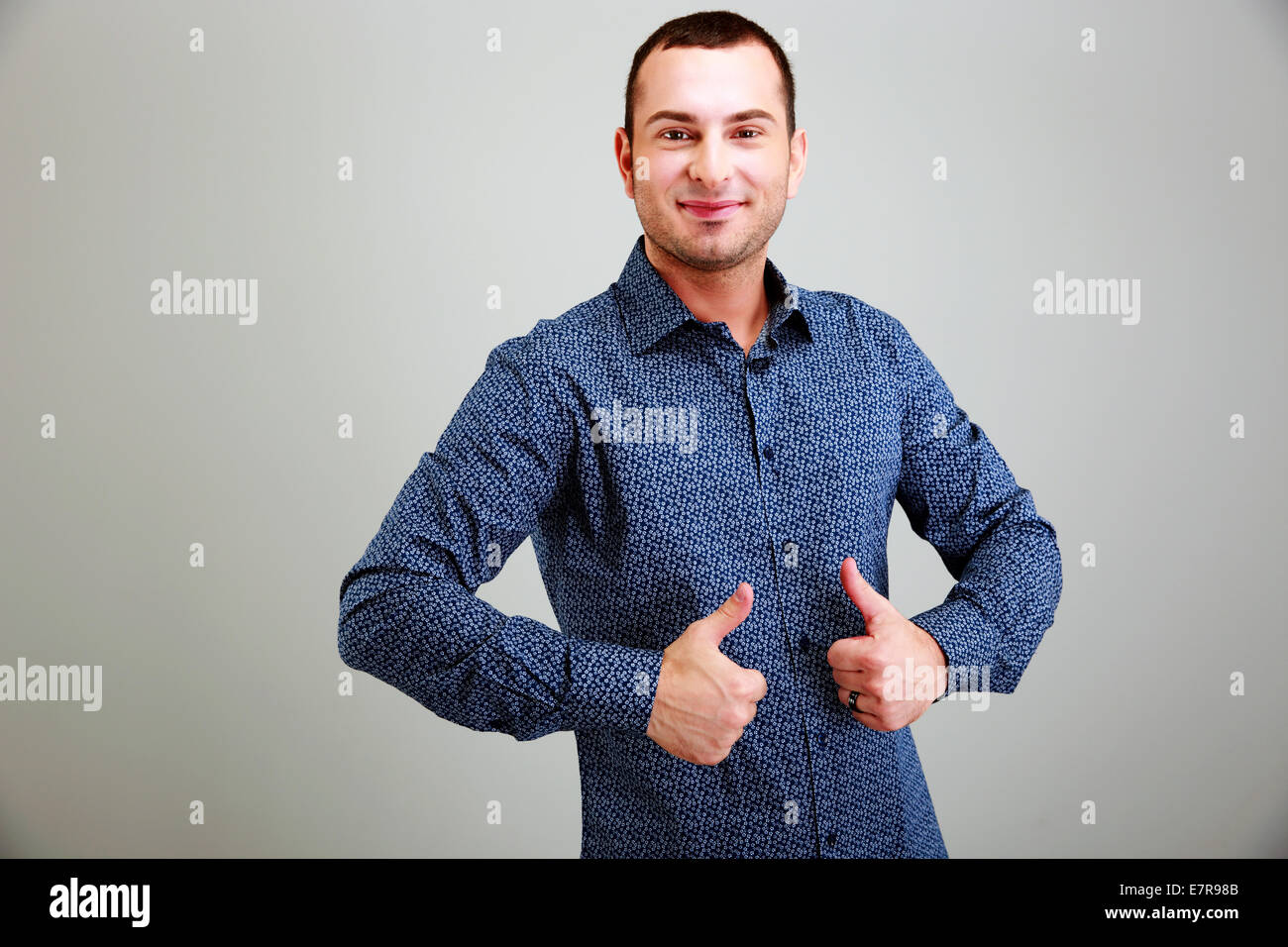 Funny man with thumbs up standing over gray background Stock Photo - Alamy