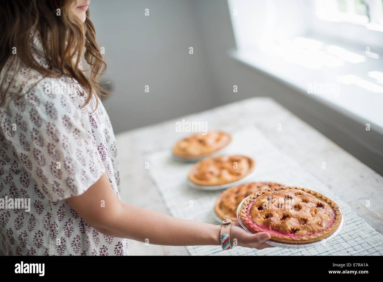 A woman carrying food to a table, preparing for a family meal Stock ...
