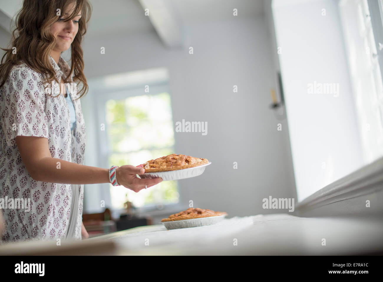 A woman carrying food to a table, preparing for a family meal Stock ...