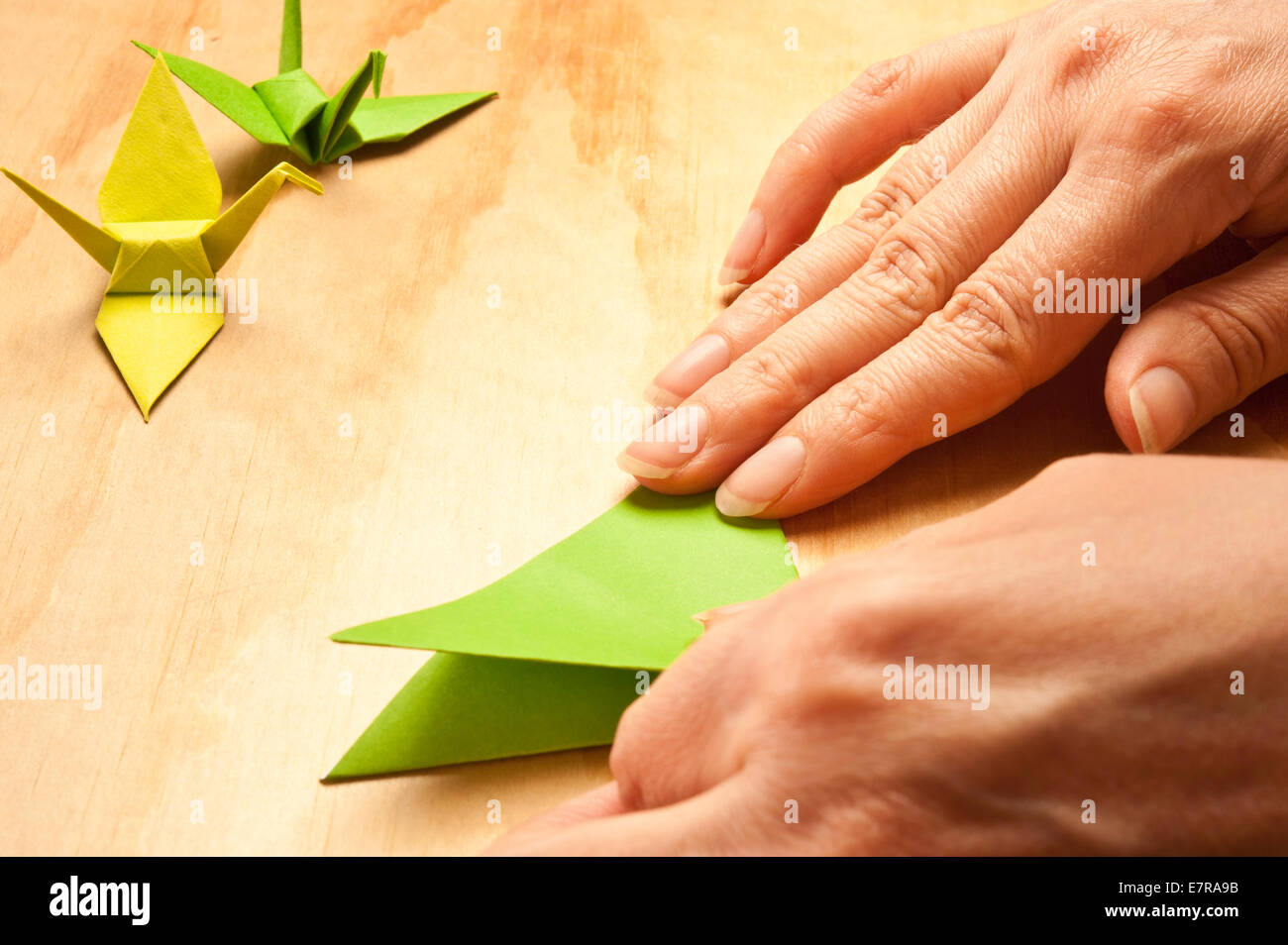 woman folding paper for origami Stock Photo - Alamy