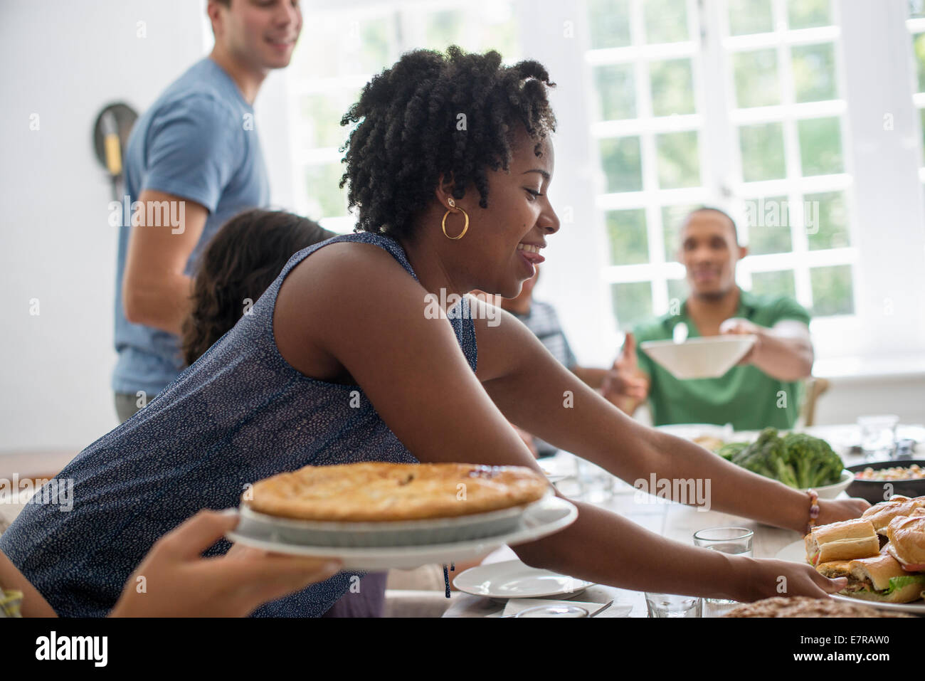 A family gathering, men, women and children around a dining table ...