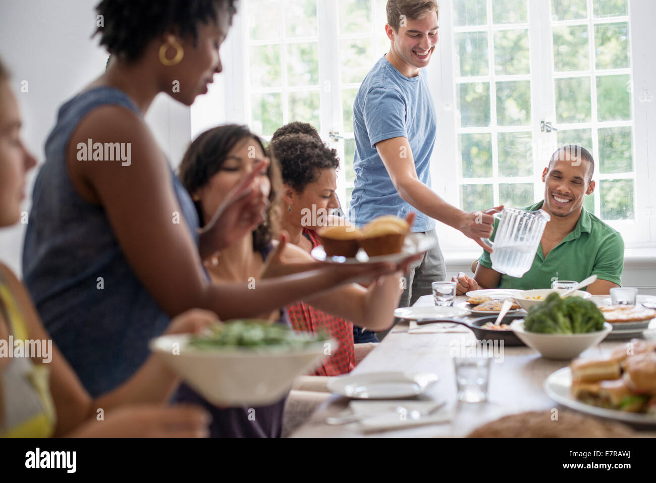A family gathering, men, women and children around a dining table ...