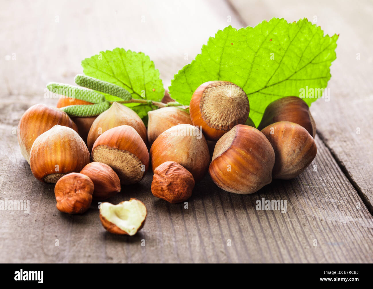 Hazelnuts with shell and green leaf on the wooden table Stock Photo - Alamy