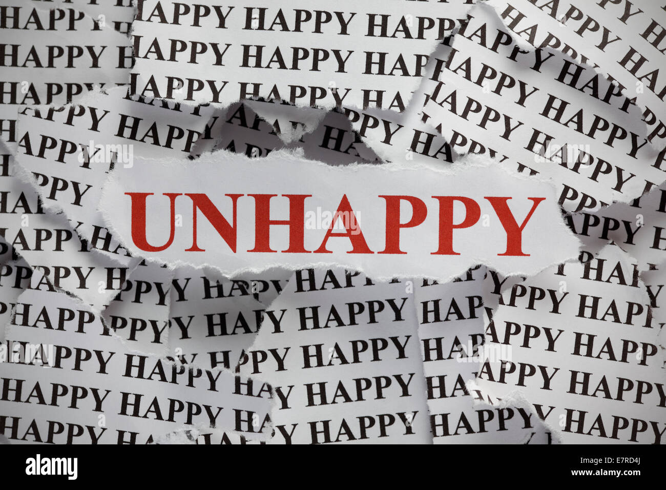 Torn pieces of paper with the word "Unhappy". Concept Image. Close-up ...