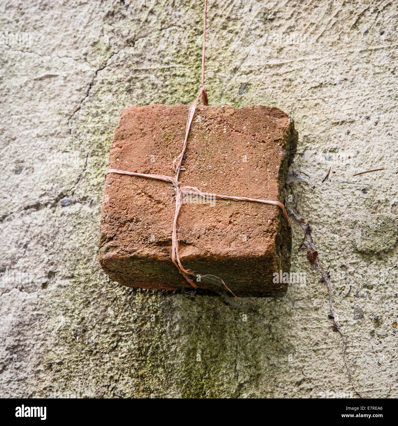 Old red brick hanging on a twine Stock Photo - Alamy