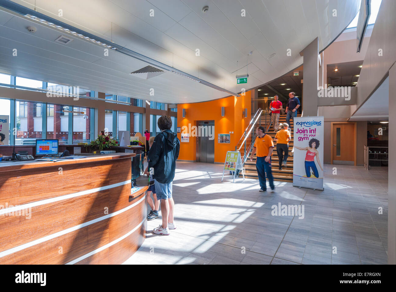 People entering a modern leisure centre reception area Stock Photo - Alamy
