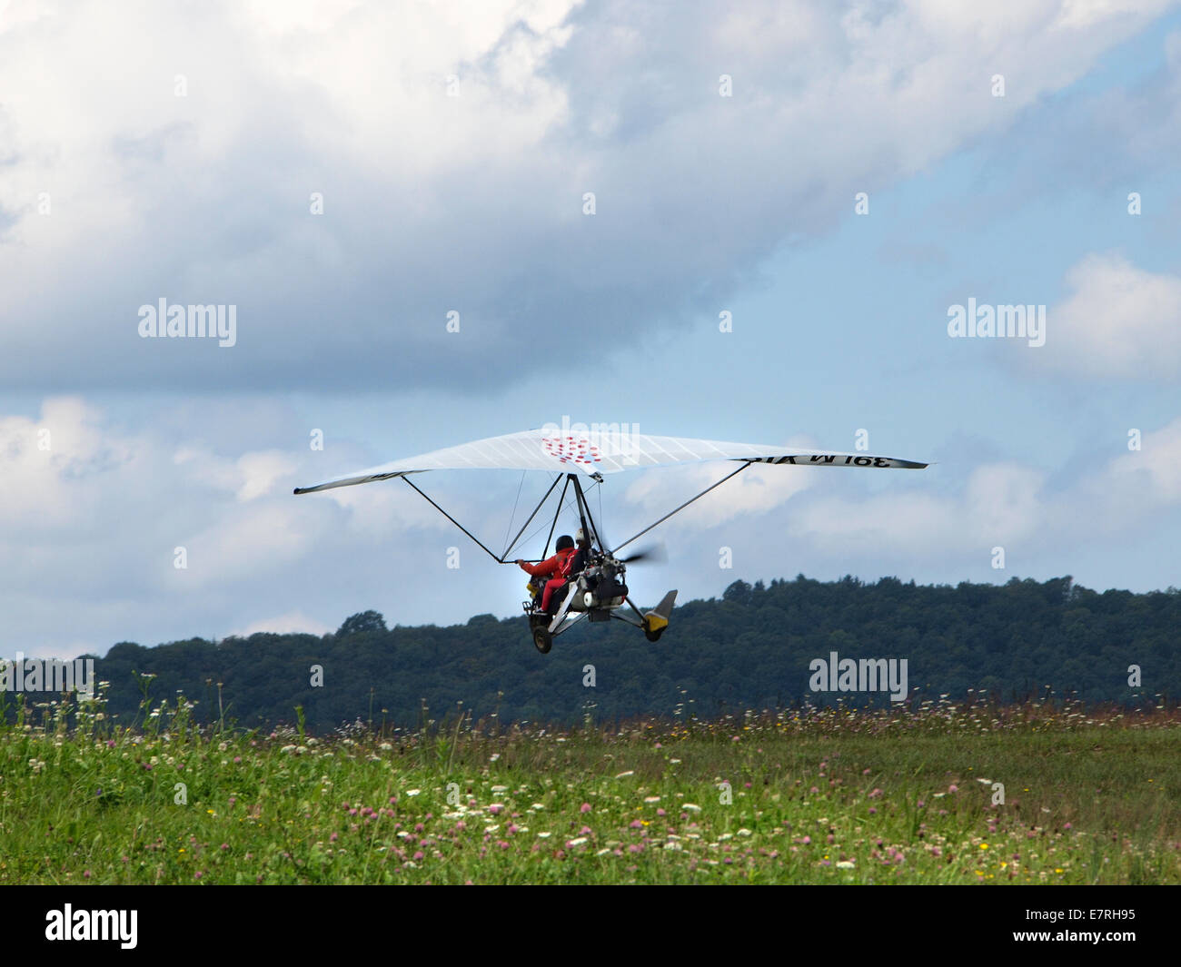 Ultralight aeroplane taking off into blue sky with clouds, Jura, France ...