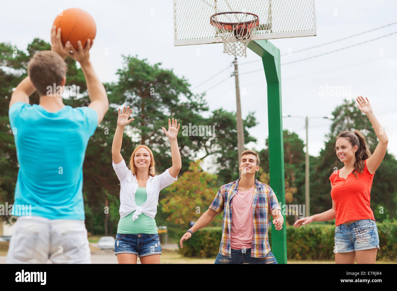 group of smiling teenagers playing basketball Stock Photo - Alamy