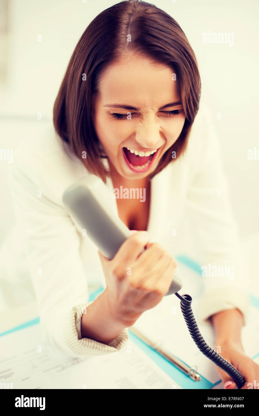 woman shouting into phone in office Stock Photo - Alamy