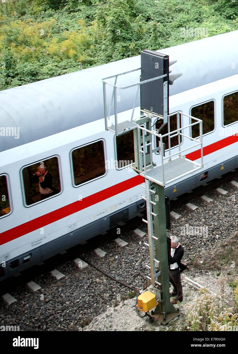 A photographer stands close to the tracks to take a train picture ...